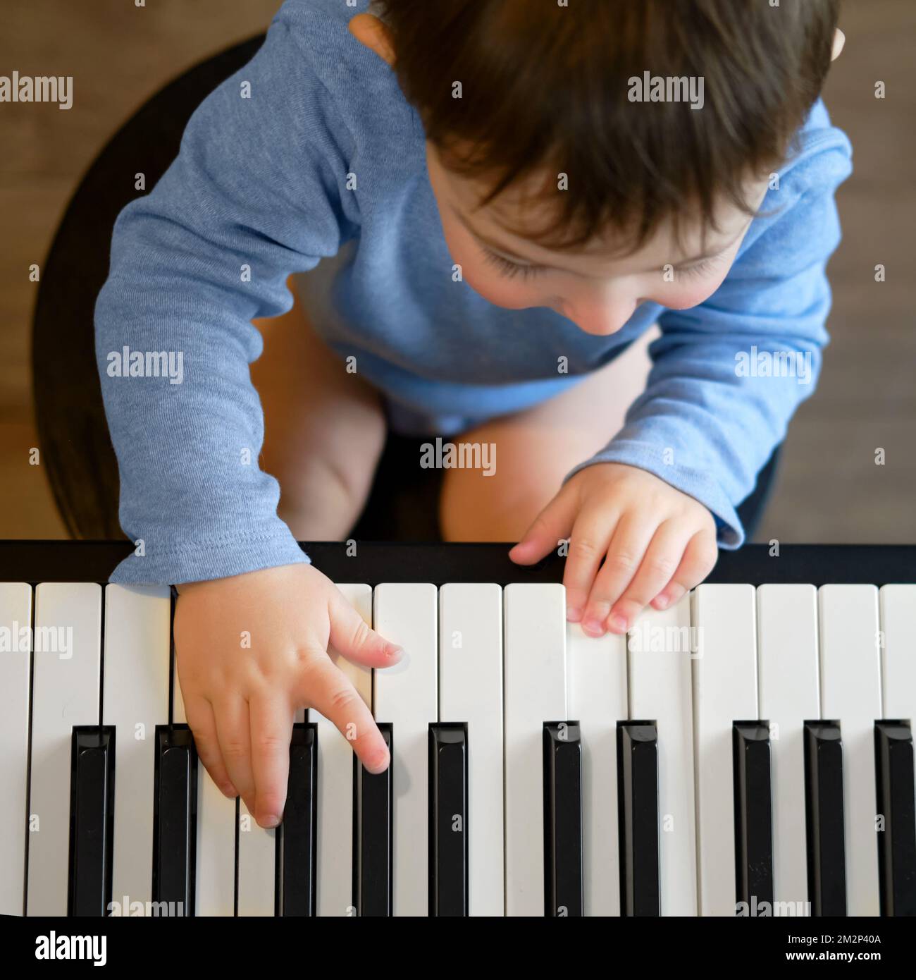Toddler baby plays piano in home living room, music lessons. Happy ...