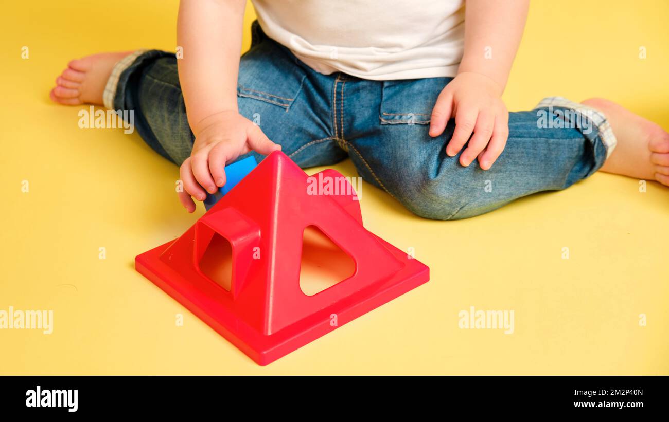 Toddler baby is playing sorter logic educational games with geometric ...