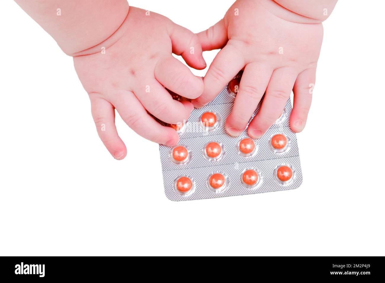Baby hand and medicines tablets in a package, close-up, isolated on a ...