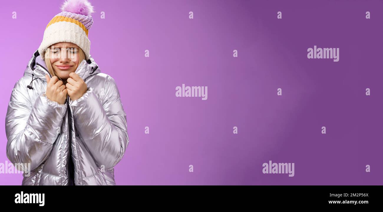 Unhappy sobbing whining cute blond girl pull jacket tight body close ...