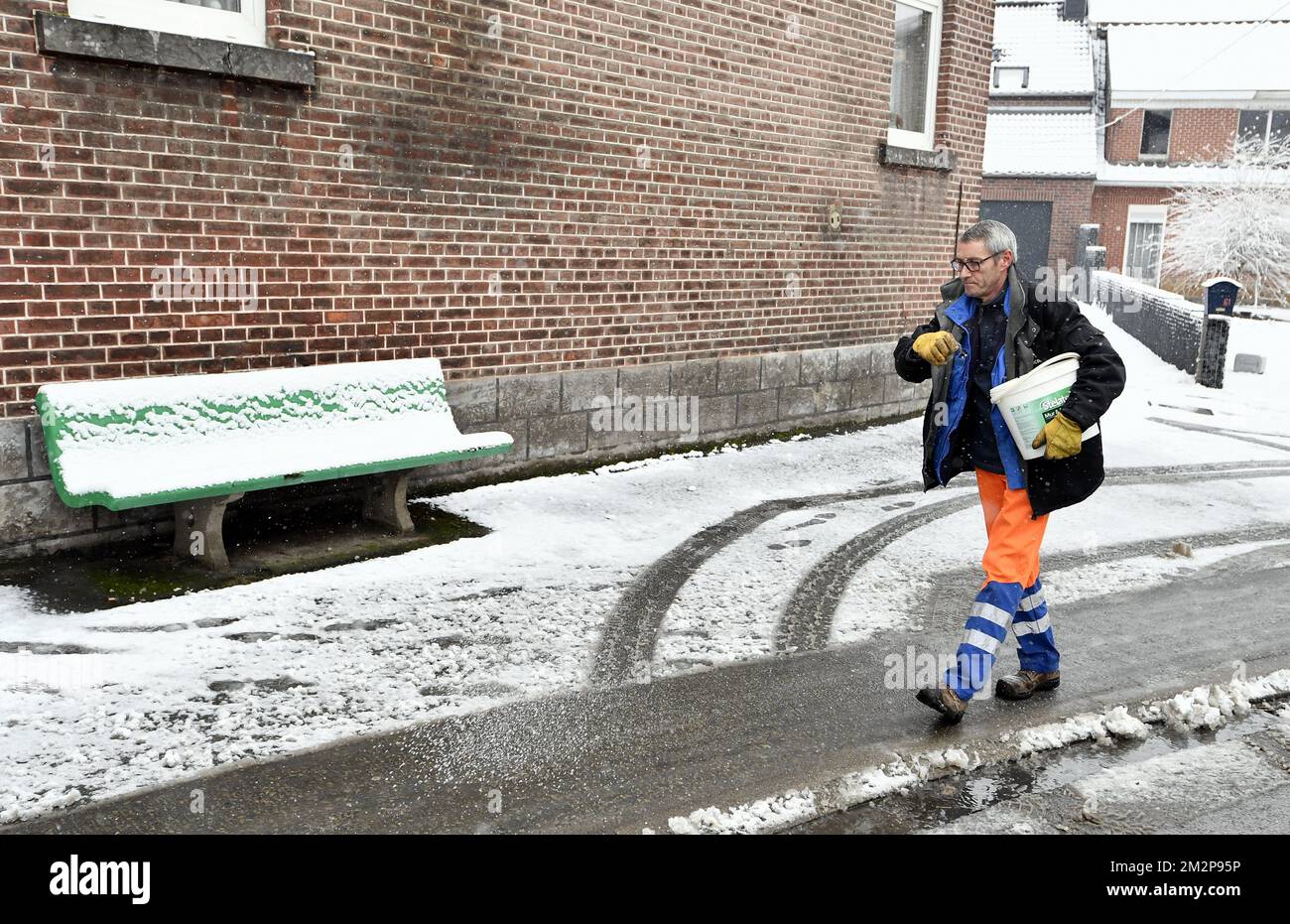 Illustration picture shows a city worker throwing some salt, part of ...