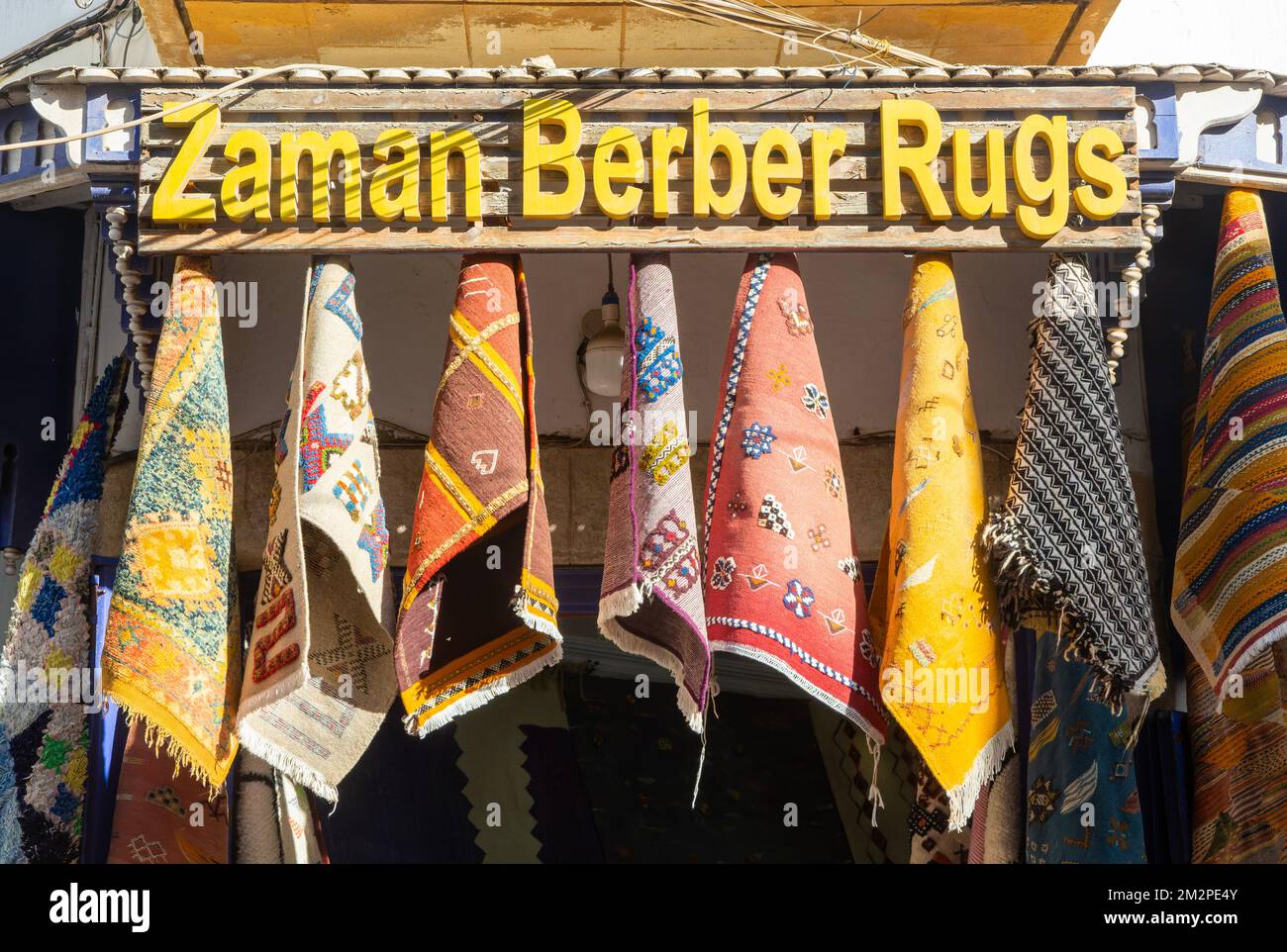 Traditional Berber rugs hanging on display outside shop in medina area ...