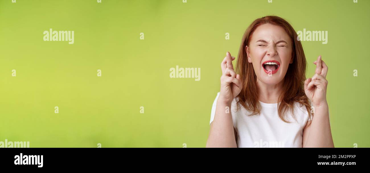 Woman implore god protection. Close eyes yelling thrilled cross fingers ...