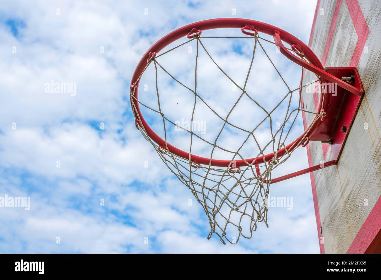 A basketball ring at the background of the sky with clouds. Side view ...