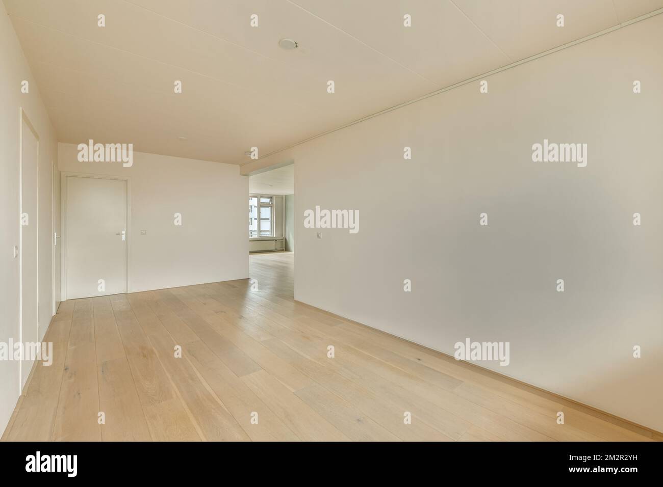 an empty room with wood floors and white walls in the corner, there is ...