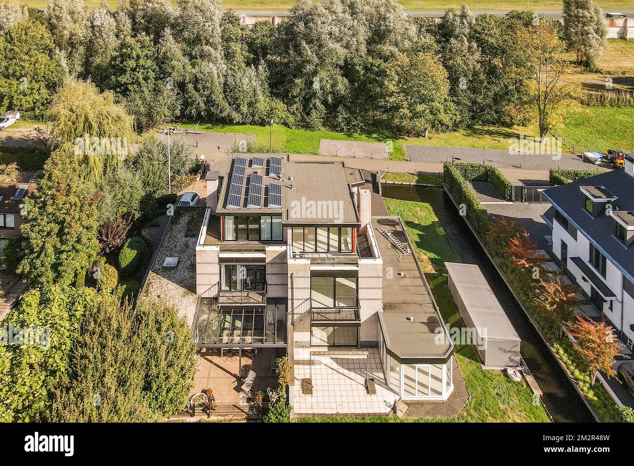 an aerial view of a house with trees and bushes in the fore - image is ...