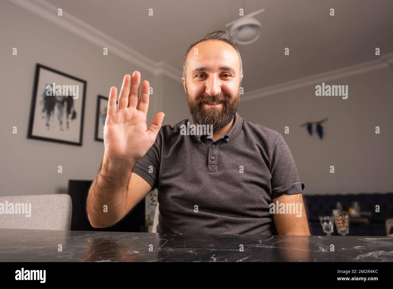 Bearded business man wave hand to camera. Web cam view of smiling young ...