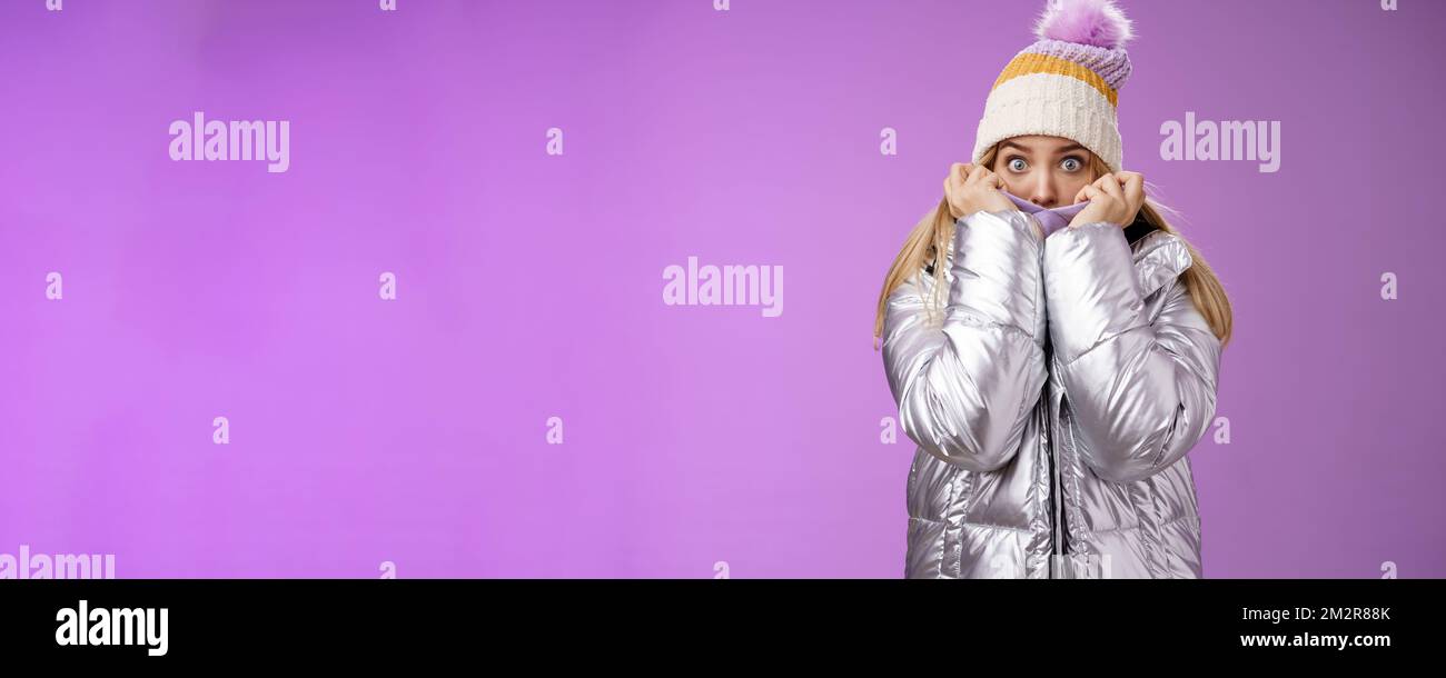 Afraid shocked young charming sister pulling jacket face cover hiding ...