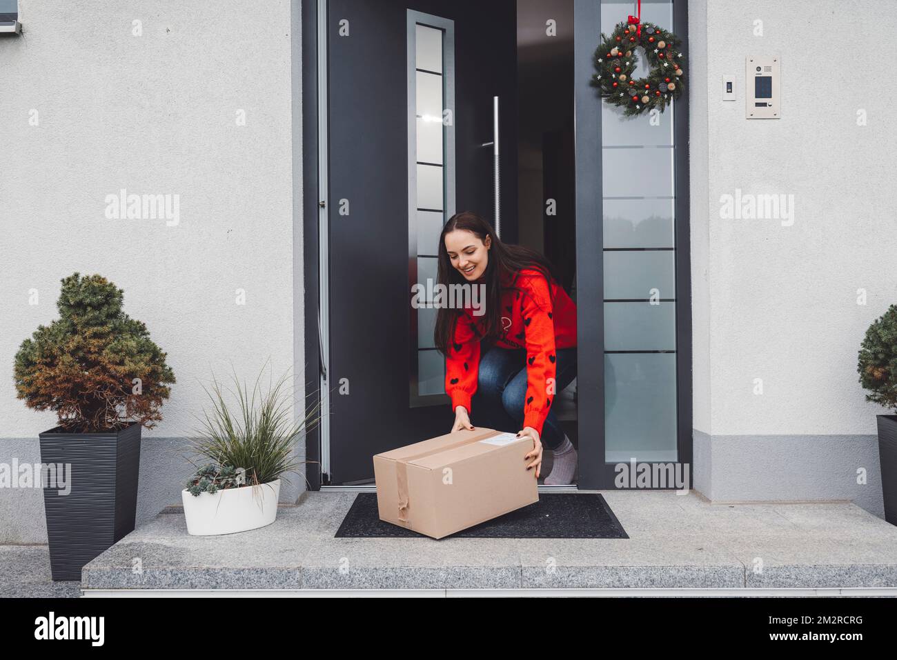 Woman picking up package hi-res stock photography and images - Alamy