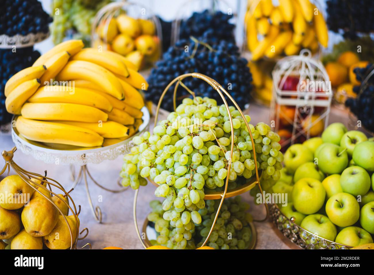 Various fresh fruits on a table arrangement, bananas, grapes, apples ...