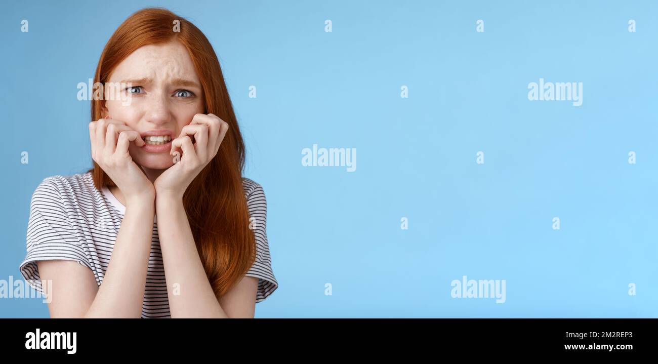 Worried uncomfortable scared young panicking redhead young girl feeling ...
