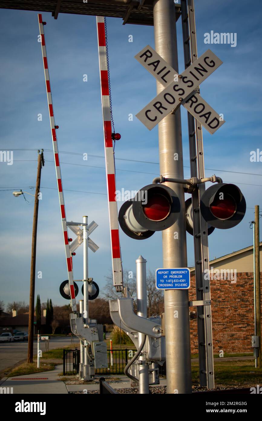 A vertical shot of rail crossing signal poles with lights and text ...