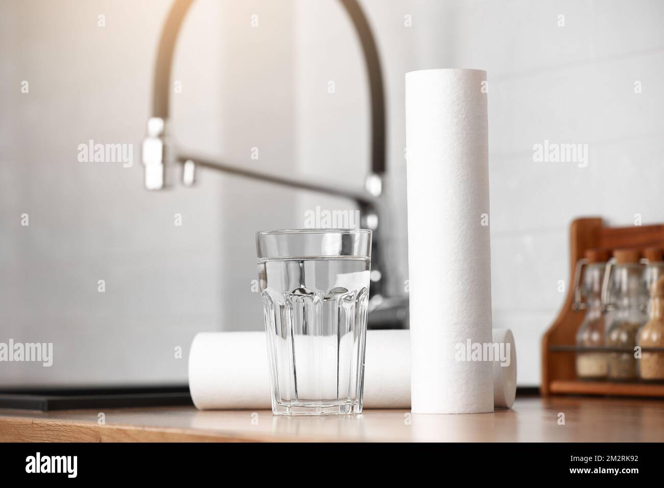 A glass of clean water and foamed polypropylene filter cartridges on ...