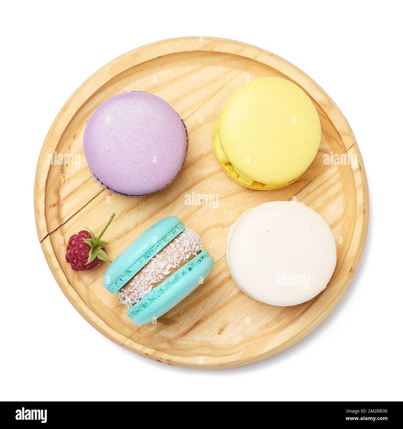 Round macaroons with different flavors on a wooden plate, top view ...