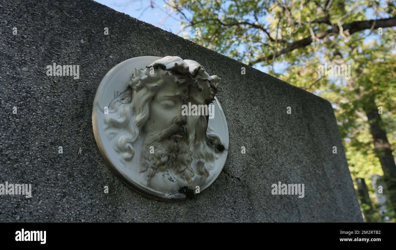 jesus head on a grave stone in the cemetery Stock Photo - Alamy