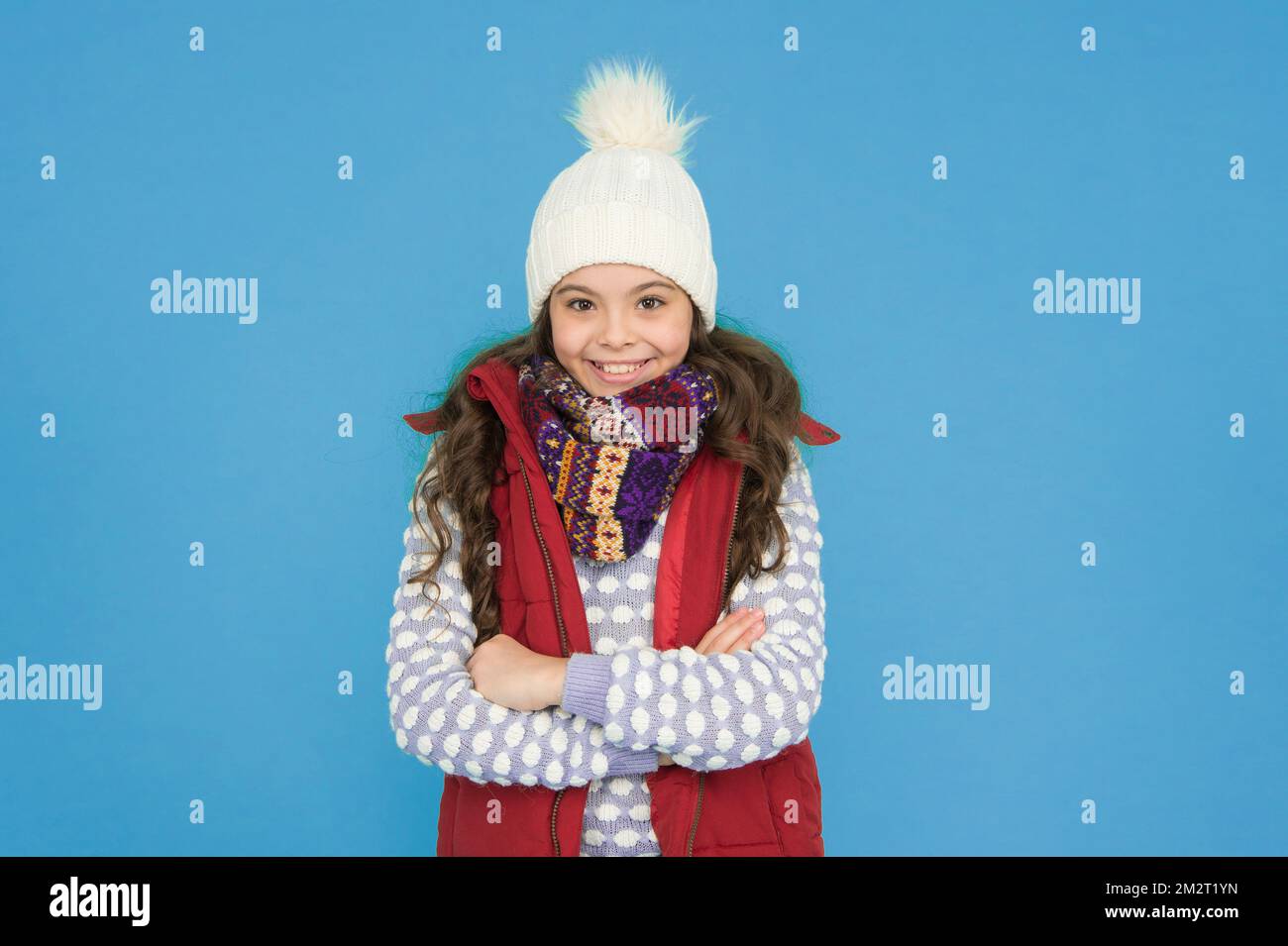child with long curly hair in knitted hat. cold season style christmas ...