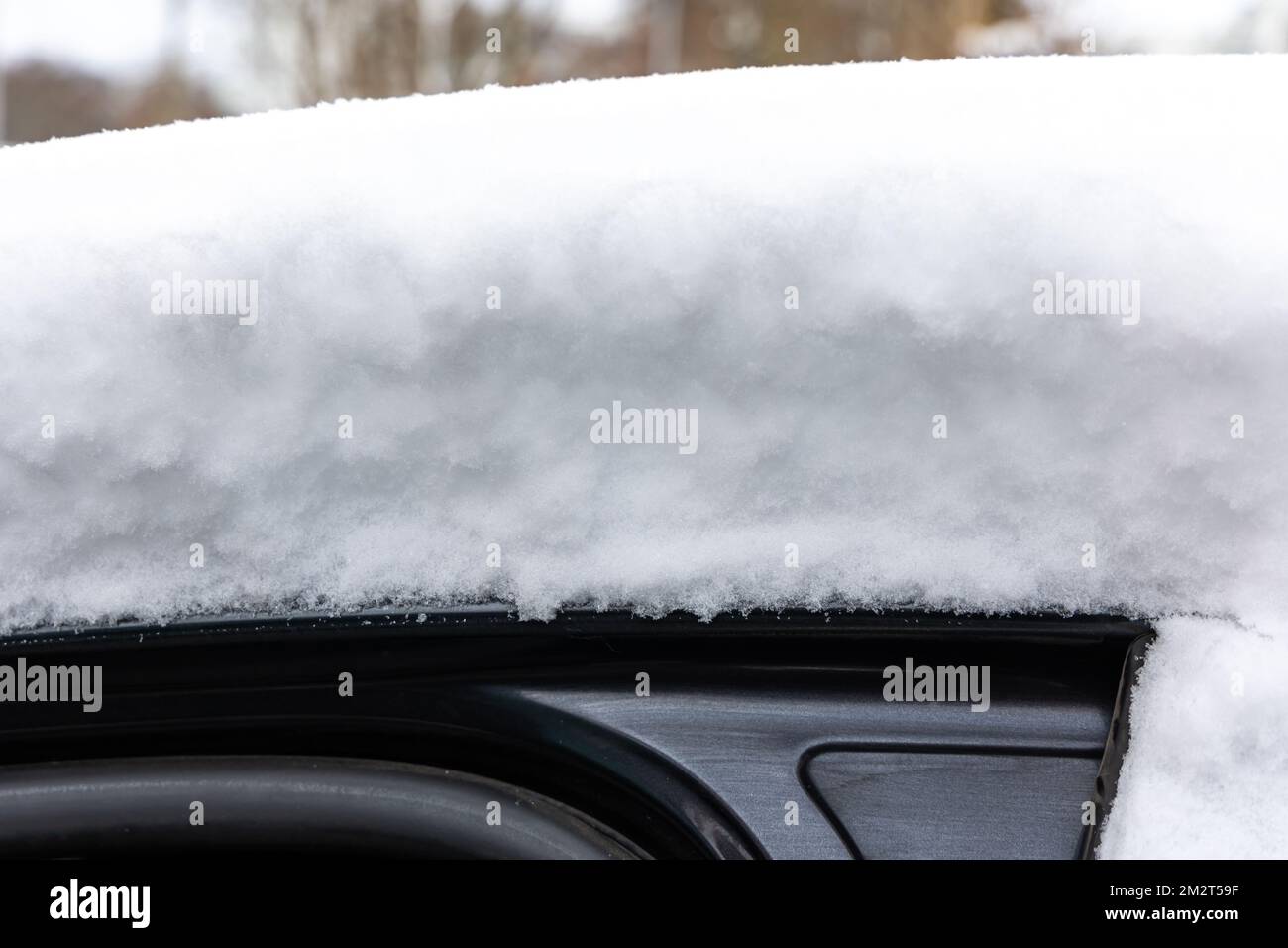 A thick layer of fresh snow on the roof of a passenger car. Heavy ...