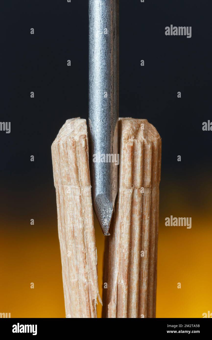 A steel nail splits a piece of wood. Close-up photo Stock Photo - Alamy