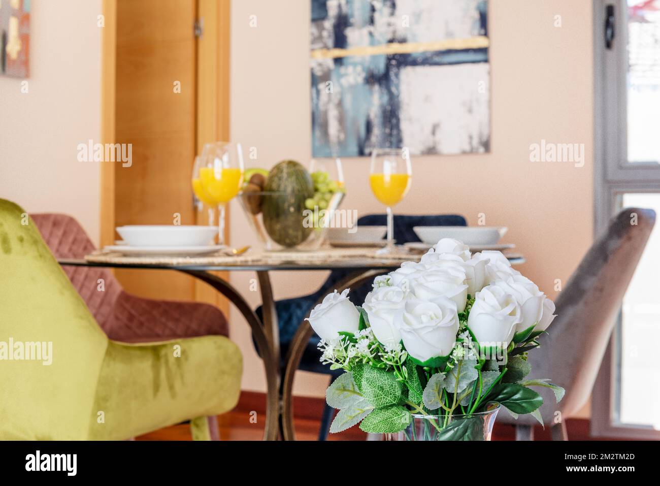 A bouquet of white artificial roses decorating a room with a table full ...