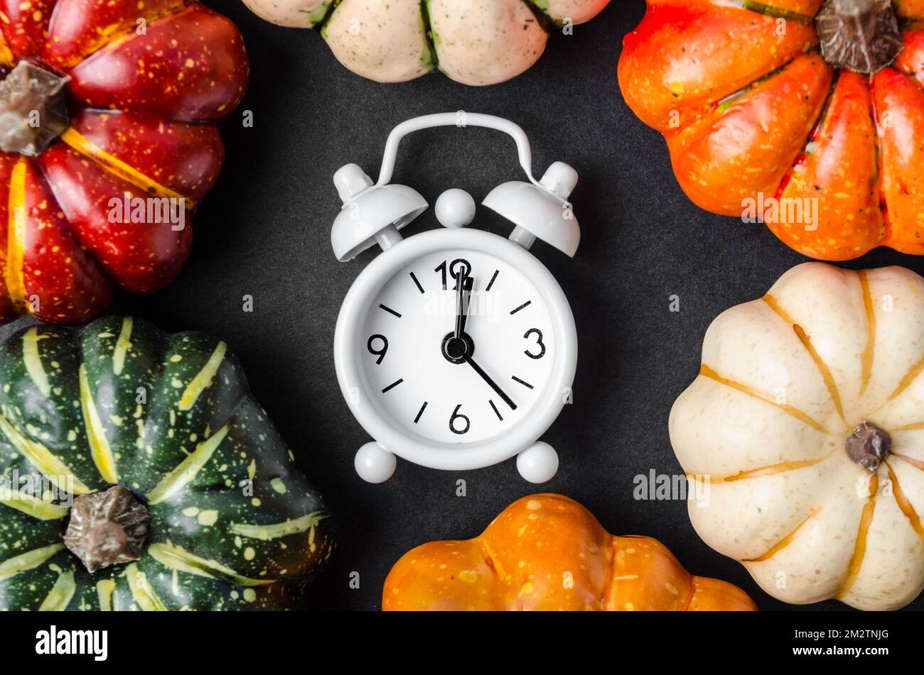 An alarm clock and pumpkins on black table Stock Photo - Alamy