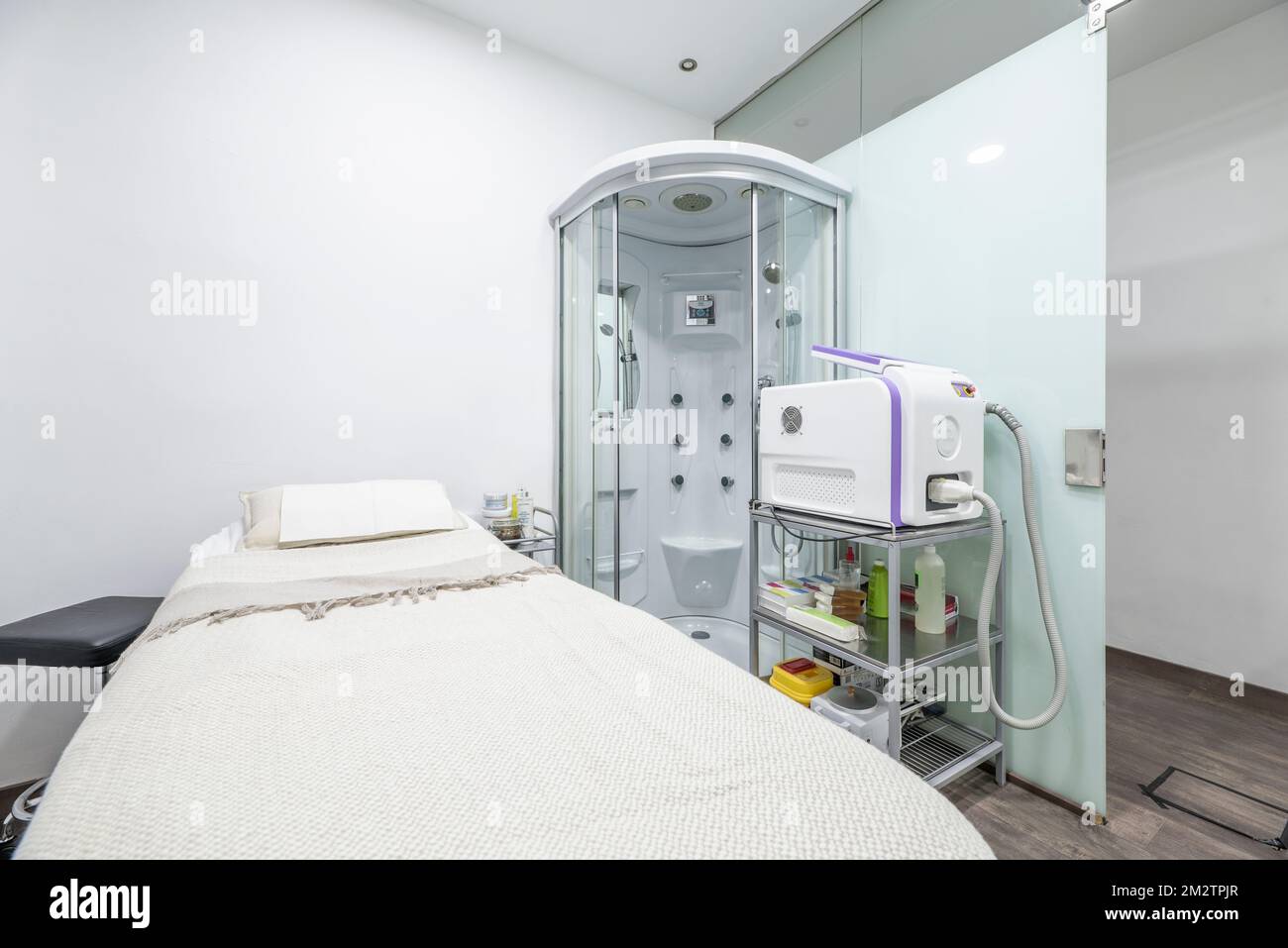 Massage cabin with table covered by towels with individual shower cabin ...