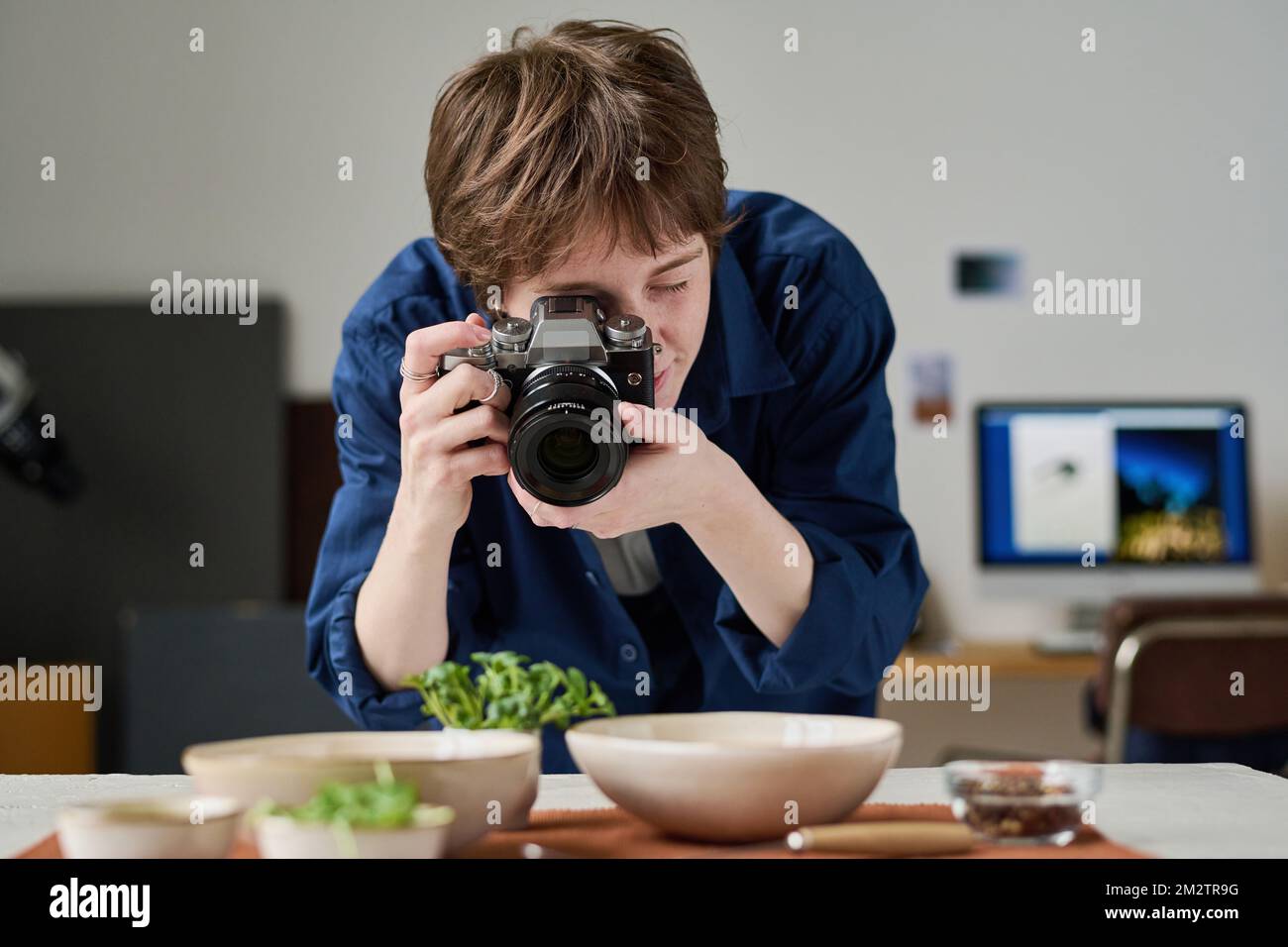 Female photographer using digital camera to take picture of food during ...