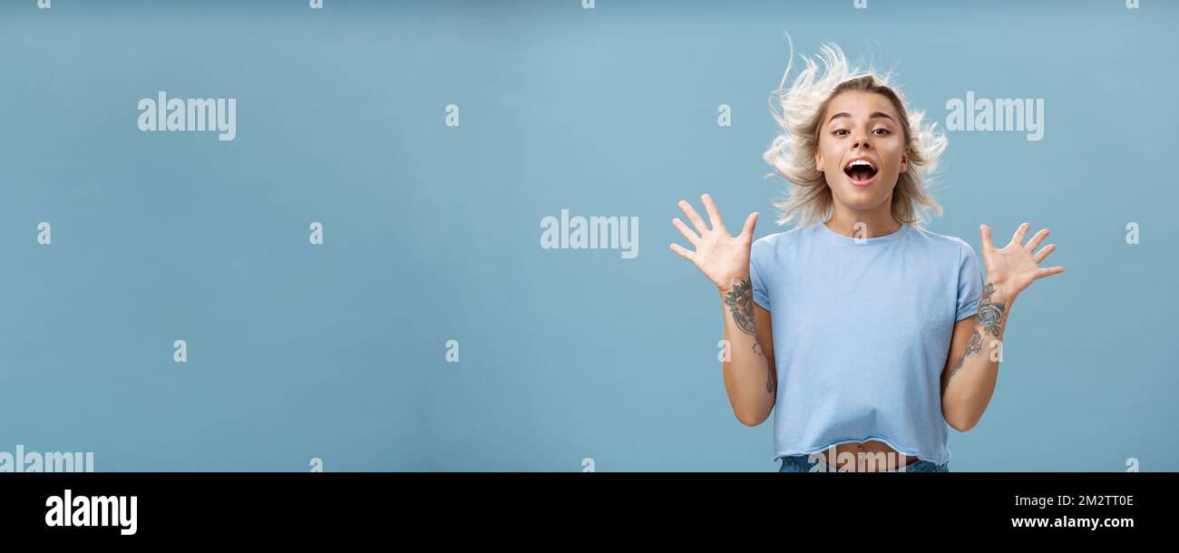 Creative happy and playful beautiful blond girl with tattoos on arms ...