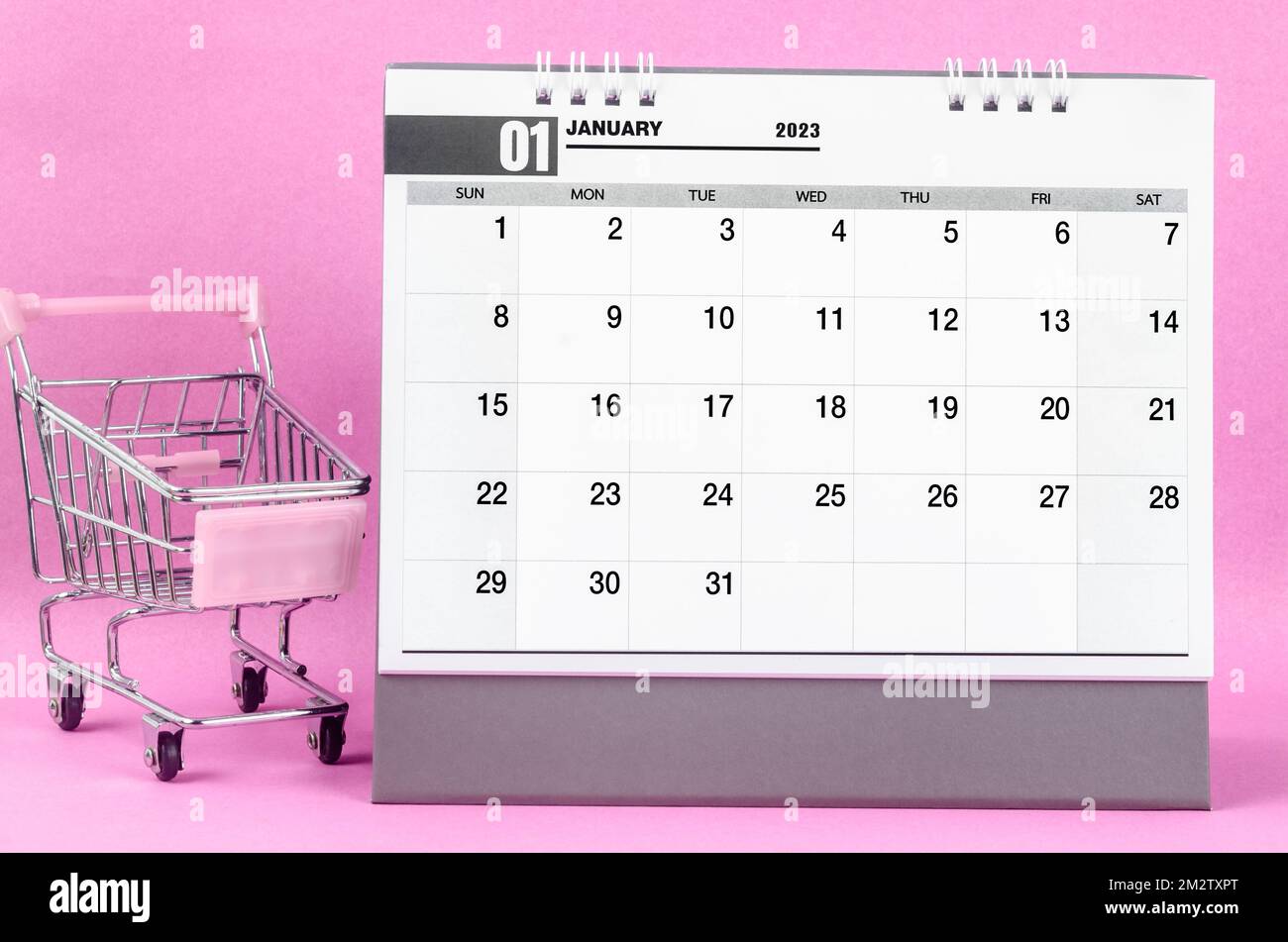 January 2023 desk calendar with shopping cart against pink background ...