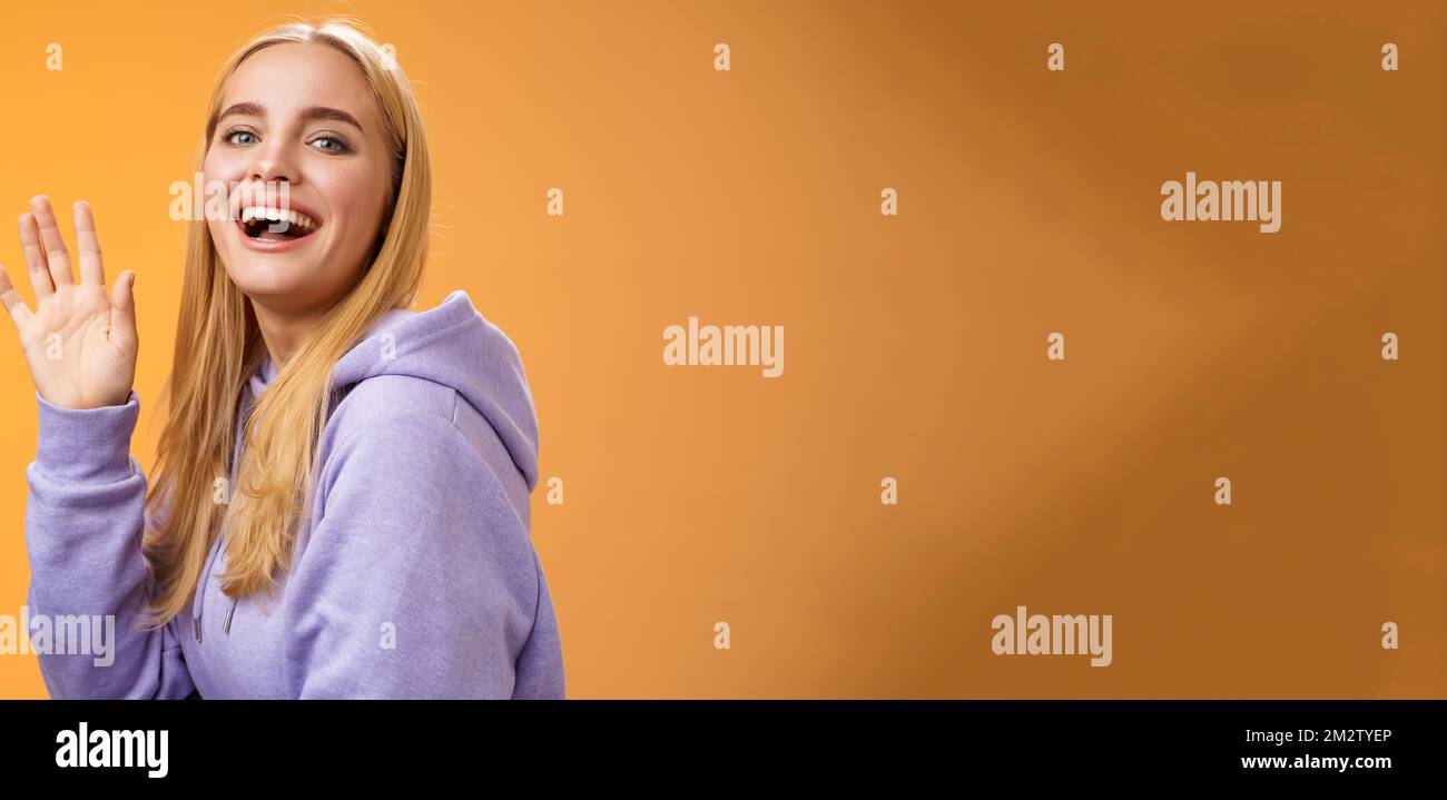 Waist-up friendly lucky cute blond girl waving palm happily smiling ...