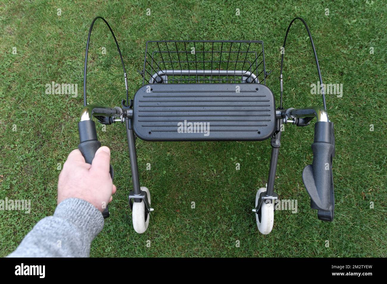Walking with a Walker Rollator outdoors. View from above. A man holding ...