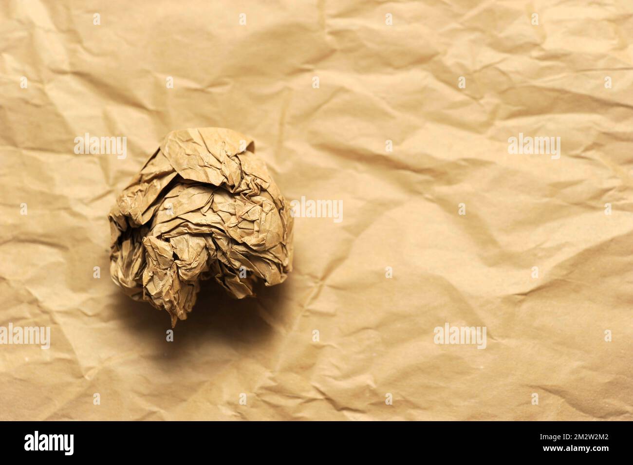 ball of paper crumpled on brown paper Stock Photo - Alamy