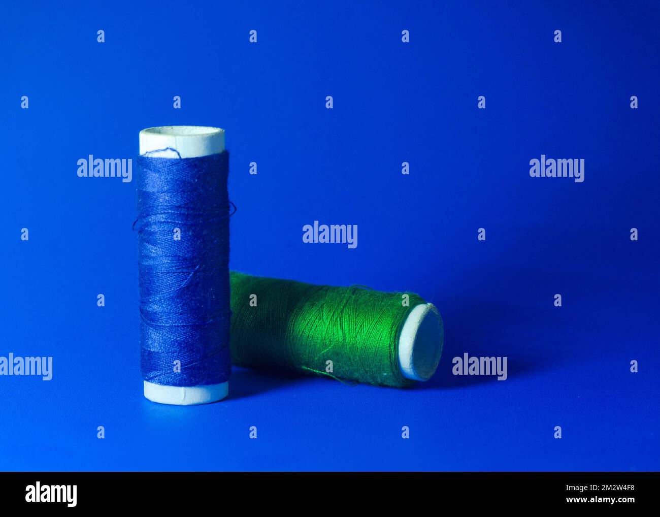 Spools of thread on a blue background. Sewing kit Stock Photo - Alamy