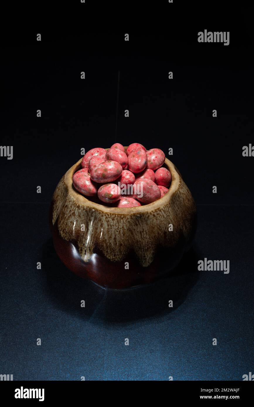 Chocolate dragees in crispy colored glaze. Dragee with almonds in a ...