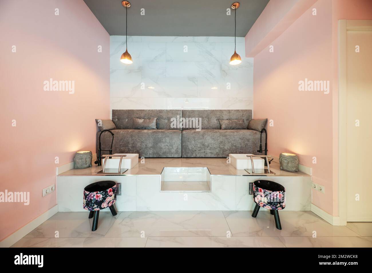 Some gray sofas on a raised platform with sinks and seats for pedicures ...