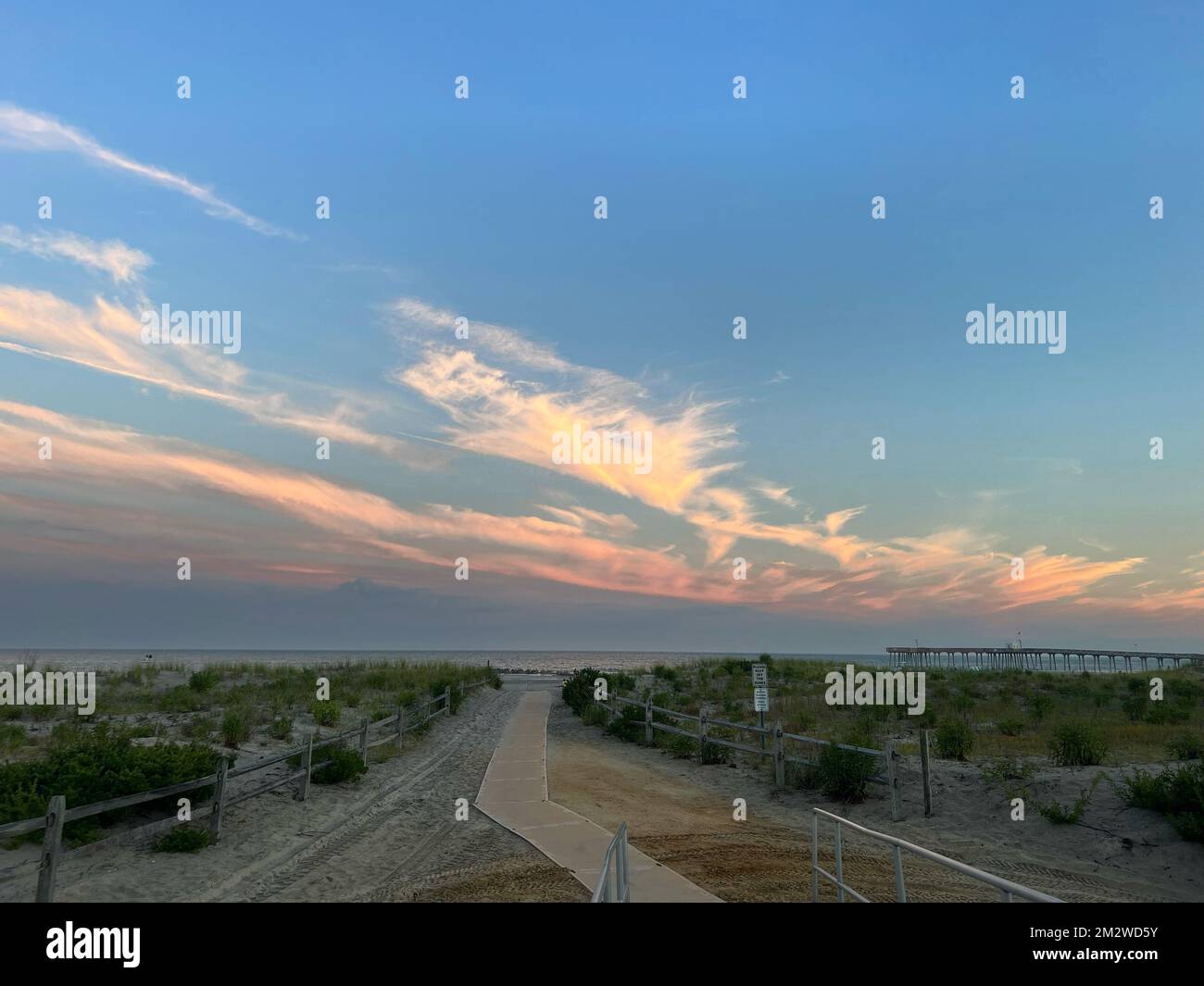 A scenic shot of an alley leading to the sea under the sunset sky Stock ...
