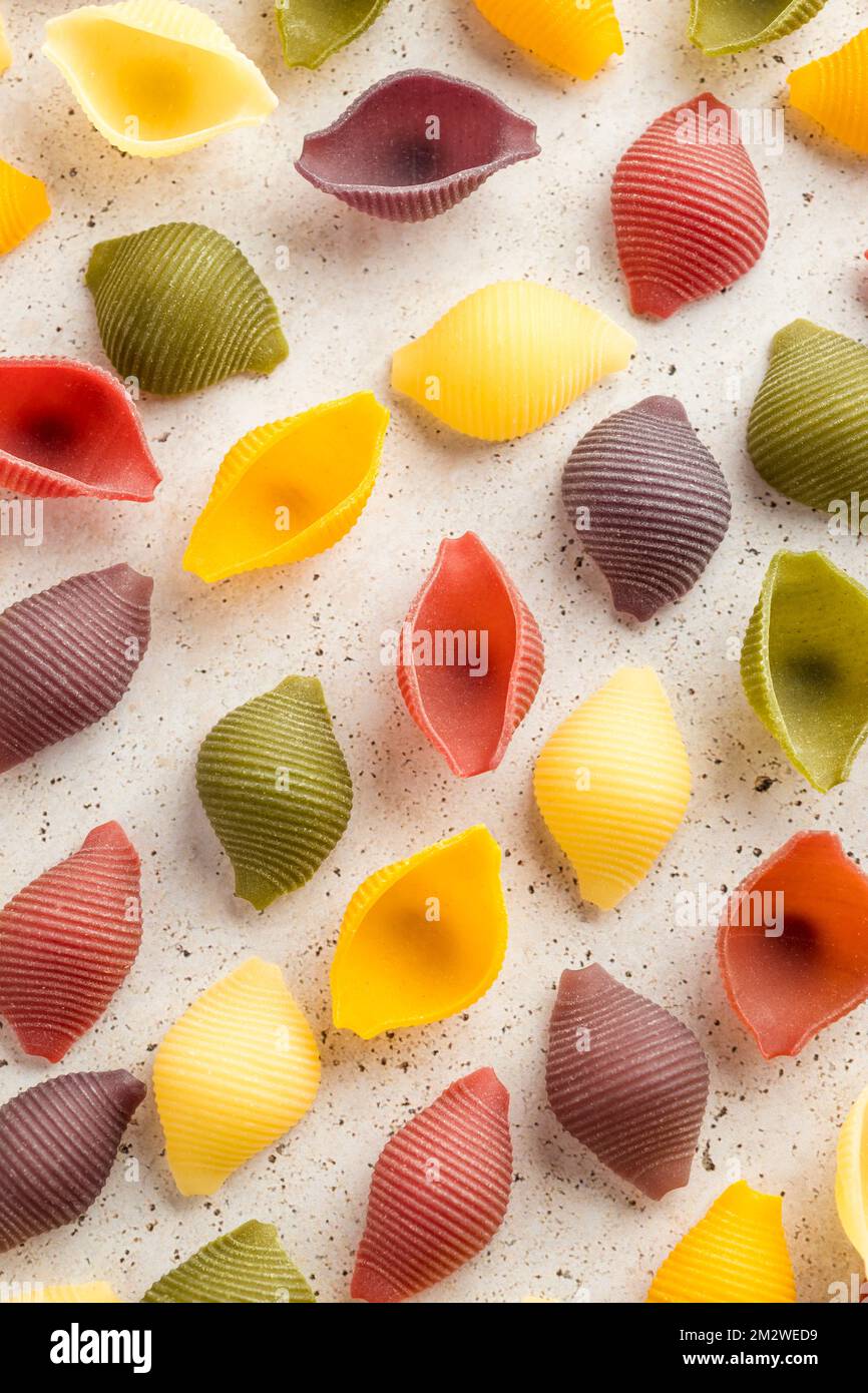 Colorful pasta background.Top view of five colors pasta shells on white ...