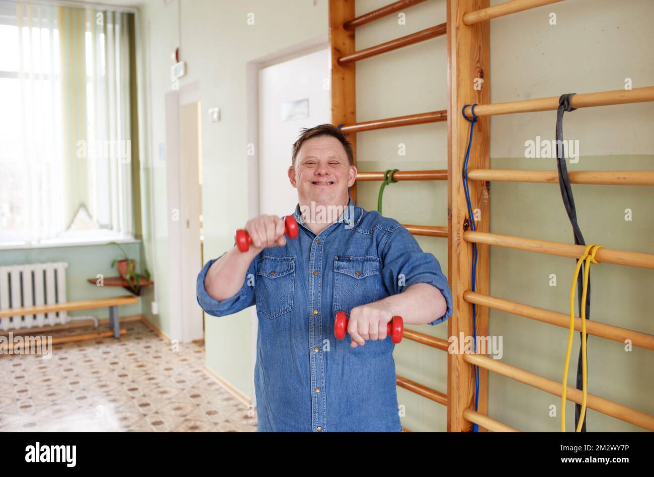 a man with down syndrome does sports with dumbbells in his hands Stock ...