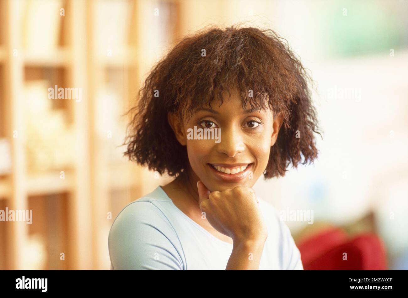 Young African-American woman posed with hand to face looking at the ...