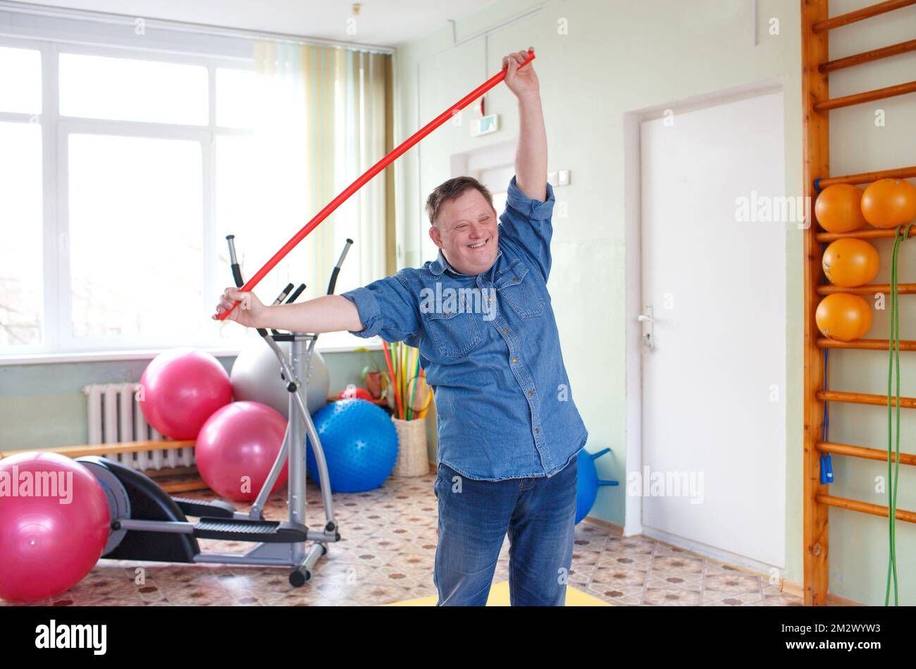 a young man with down syndrome is engaged in a gym with a gymnastic ...