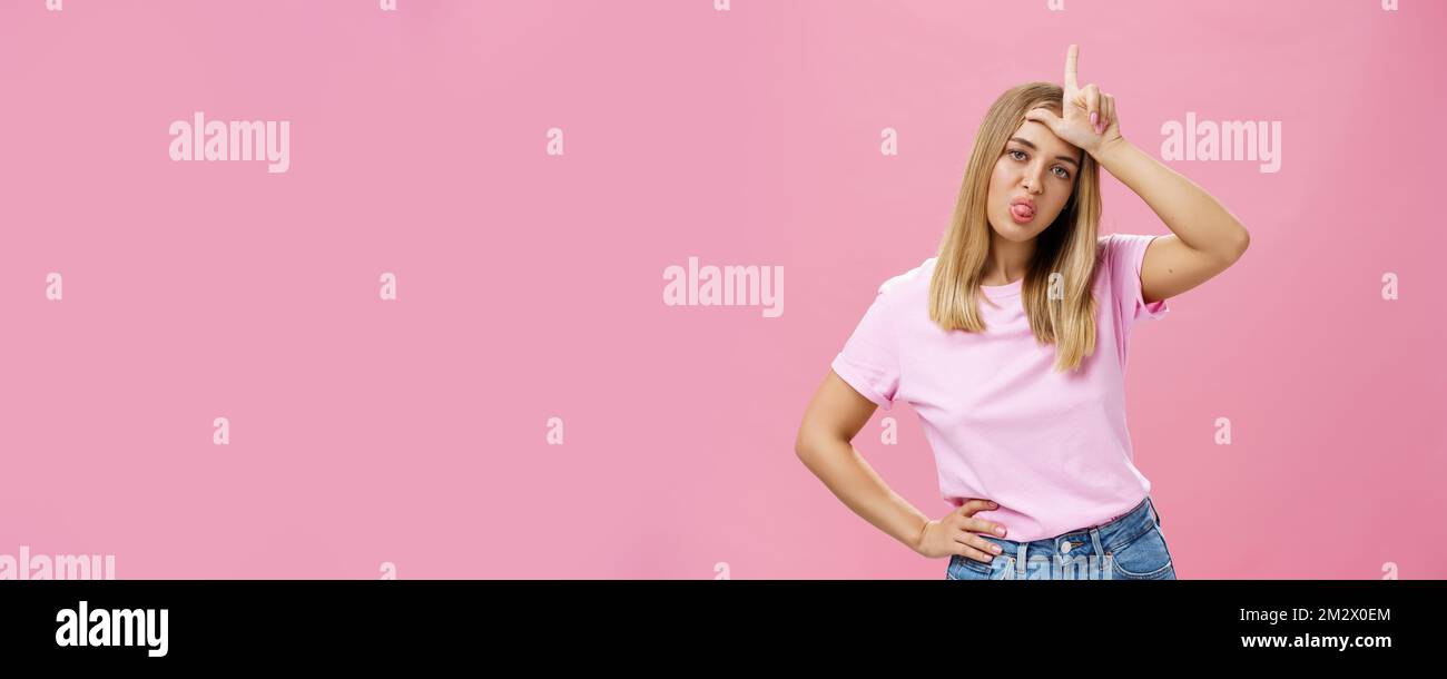 Girl mocking under boyfriend showing loser sign on forehead sticking ...