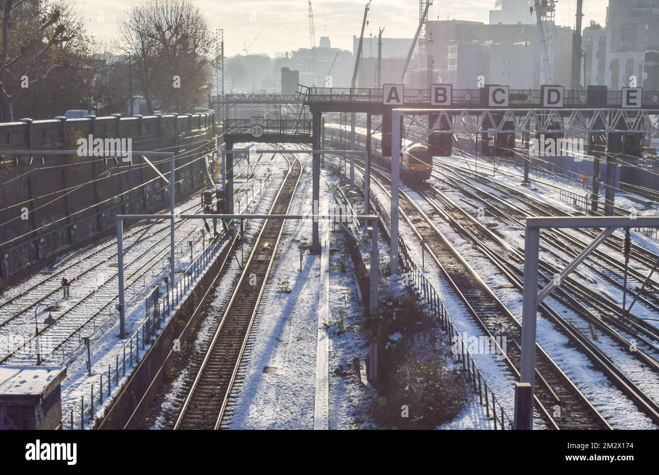 London, UK. 14th December 2022. A train passes along snow and ice ...
