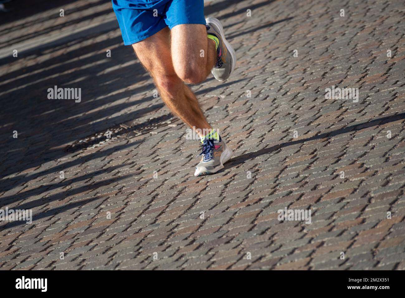 Running Race, Male Feet on Porphyry Cobblestone Stock Photo - Alamy