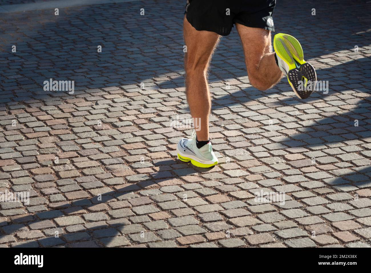 Running Race, Male Feet on Porphyry Cobblestone Stock Photo - Alamy