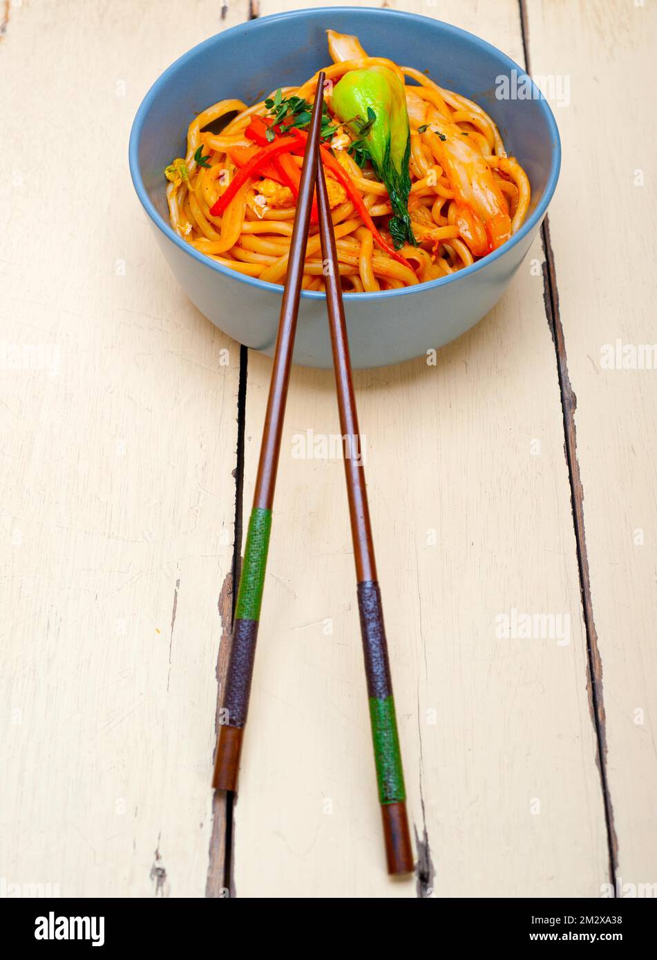 Hand pulled stretched Chinese ramen noodles on a bowl with chopstick ...