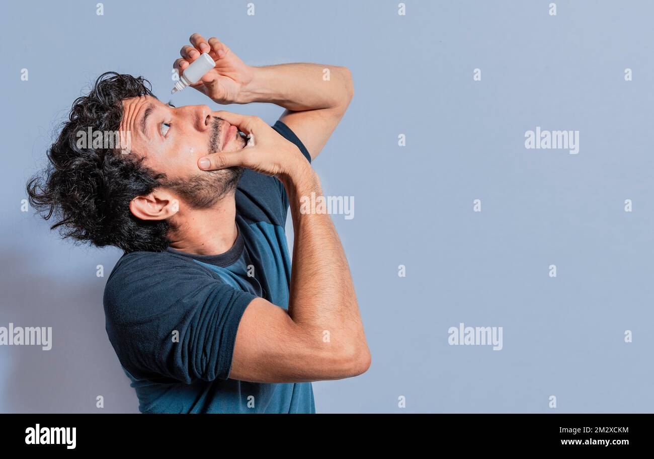 People applying refreshing drops to irritated eye. Man putting a ...