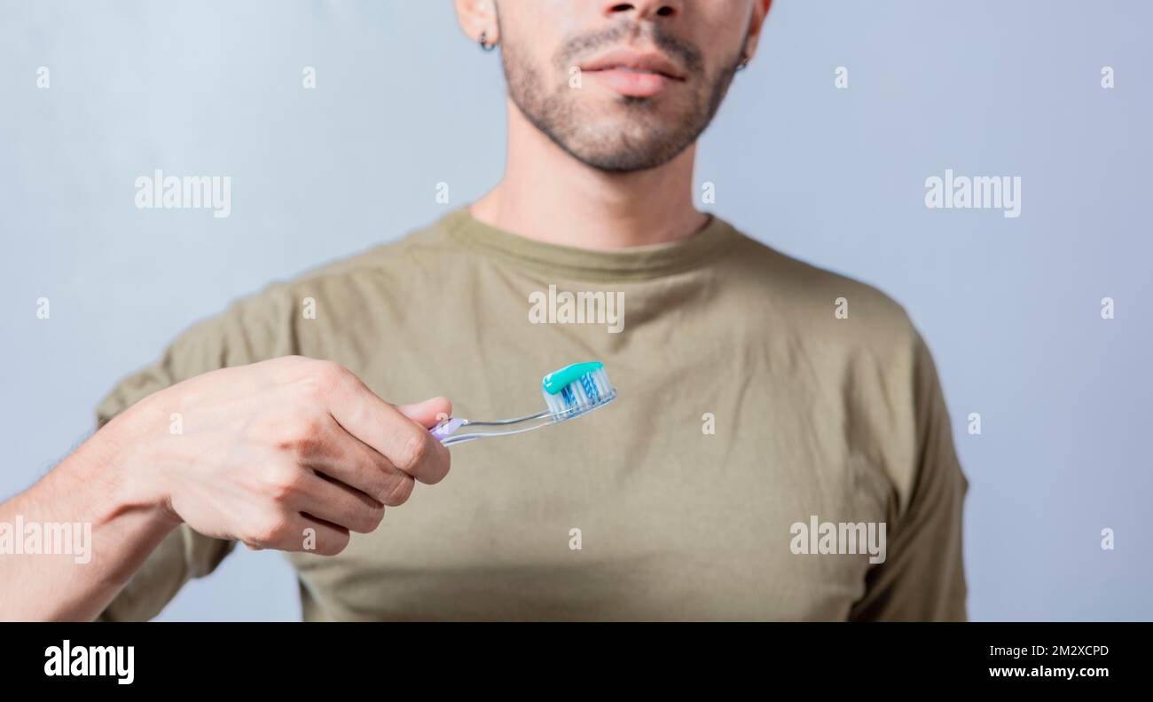 Guy with unrecognizable face holds brush with toothpaste on isolated ...