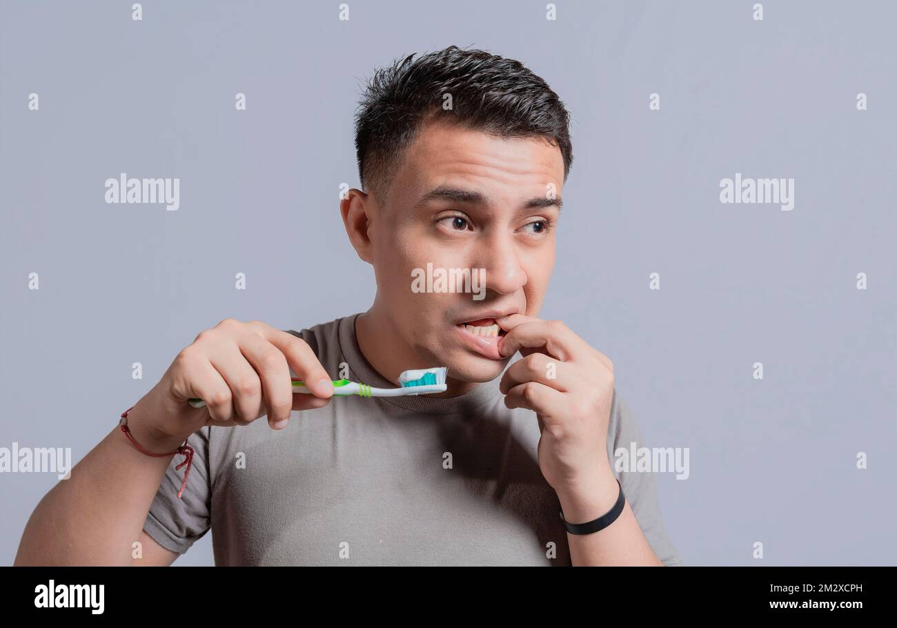 Young man with gingivitis holding toothbrush. People holding toothbrush ...