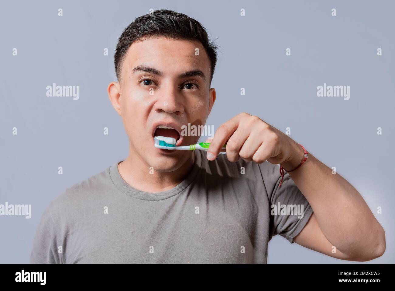 Handsome guy brushing his teeth isolated, Close up of handsome man ...