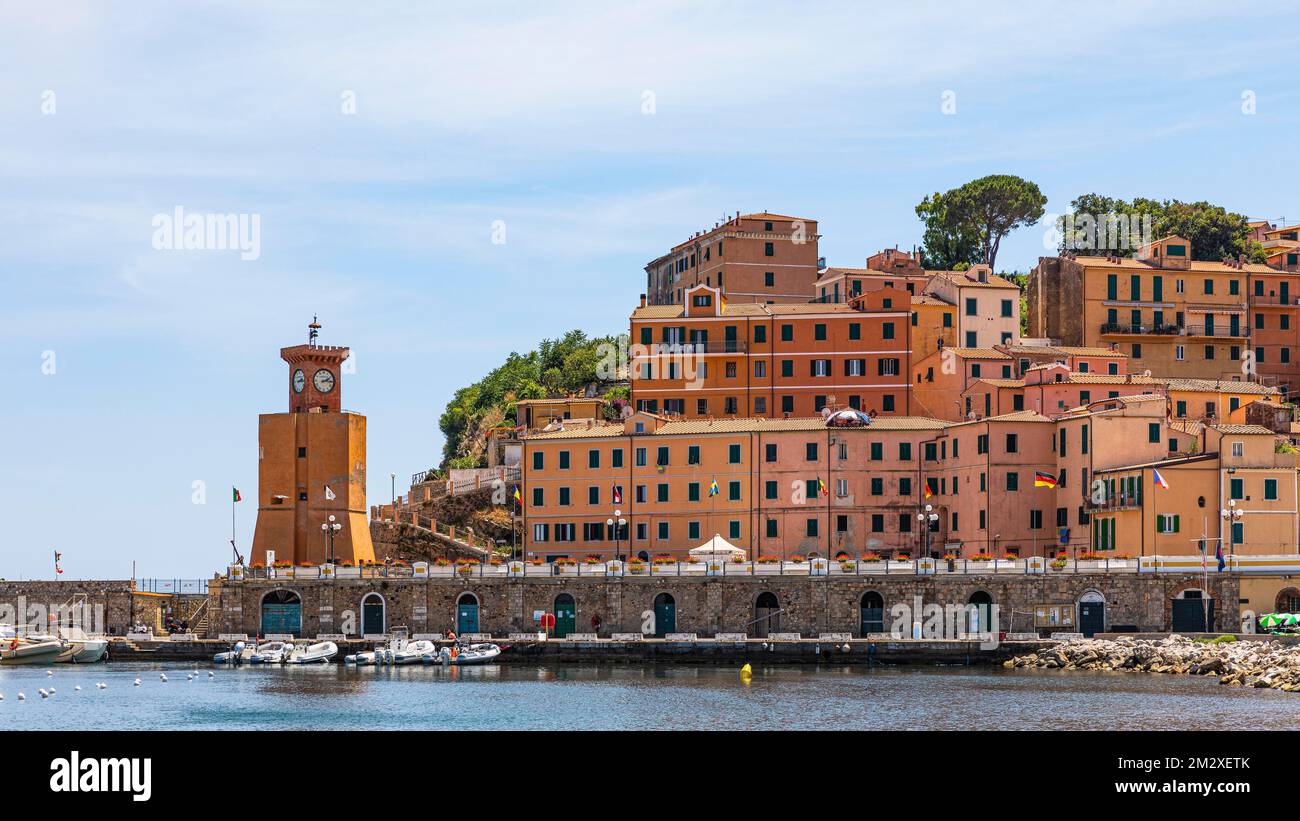 Lighthouse next to houses in pastel-coloured facades, Rio Marina, Elba ...