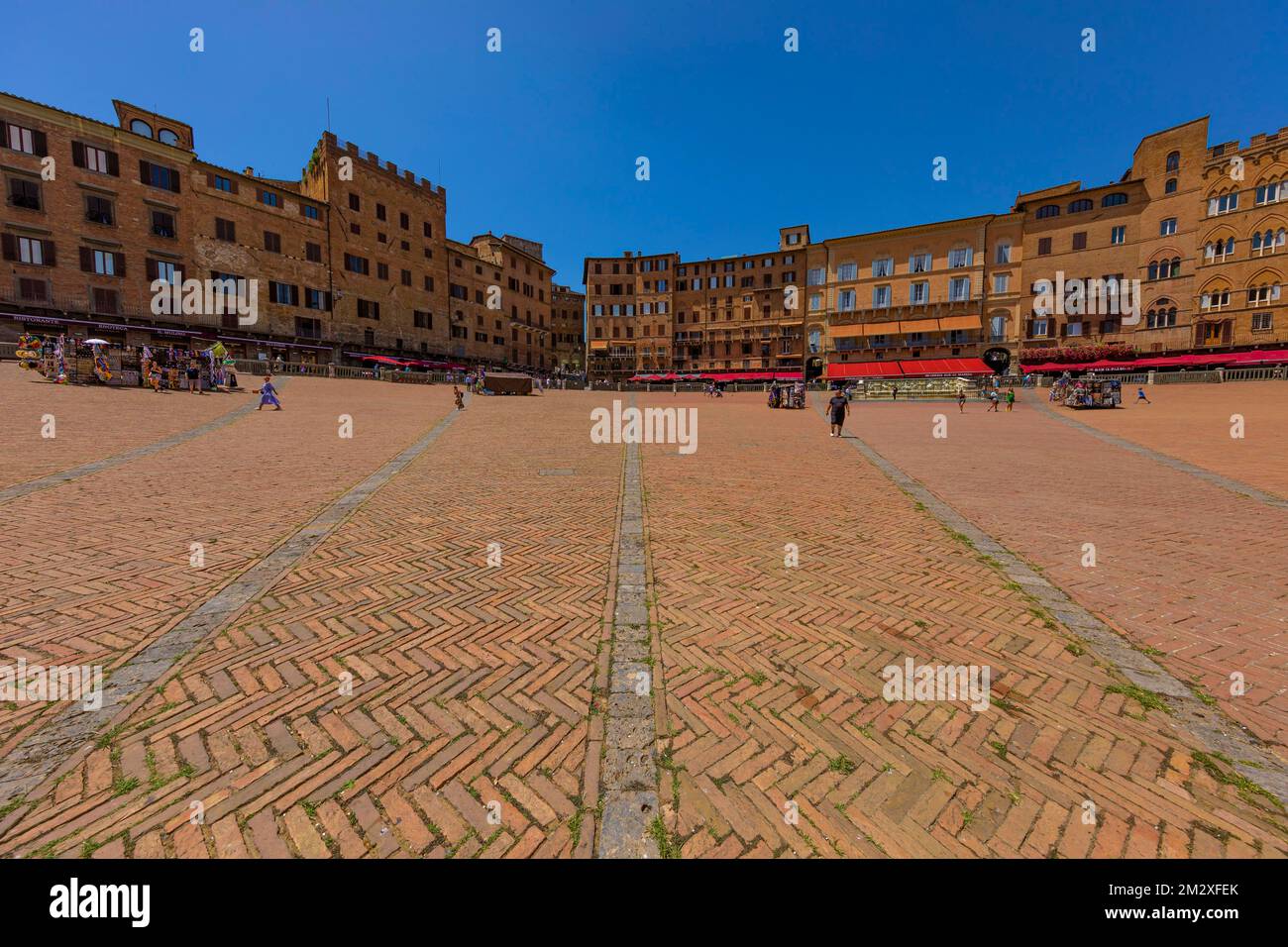 Brick pavement at the Piazza del Campo, behind medieval palaces with ...